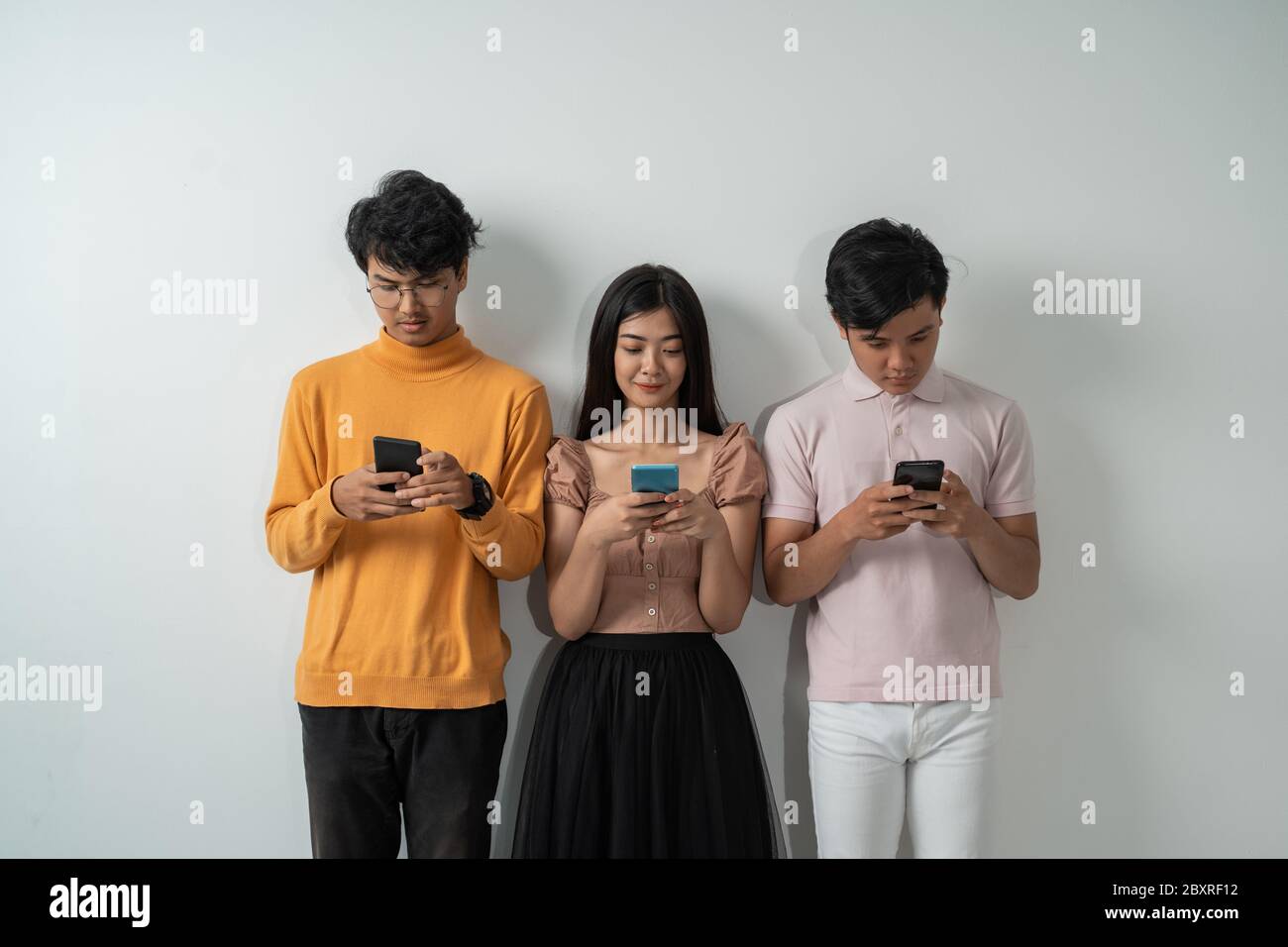 group of young asian friends with serious expressions while using their ...