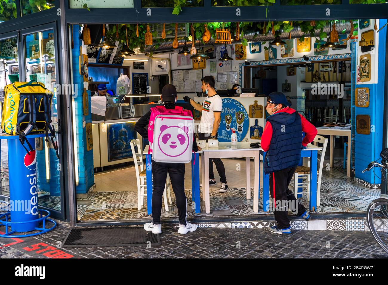Food Panda and Glovo food delivery courier waiting to pick up order in ...