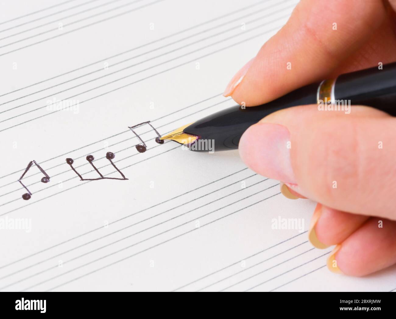 Hand with pen and music sheet Stock Photo - Alamy