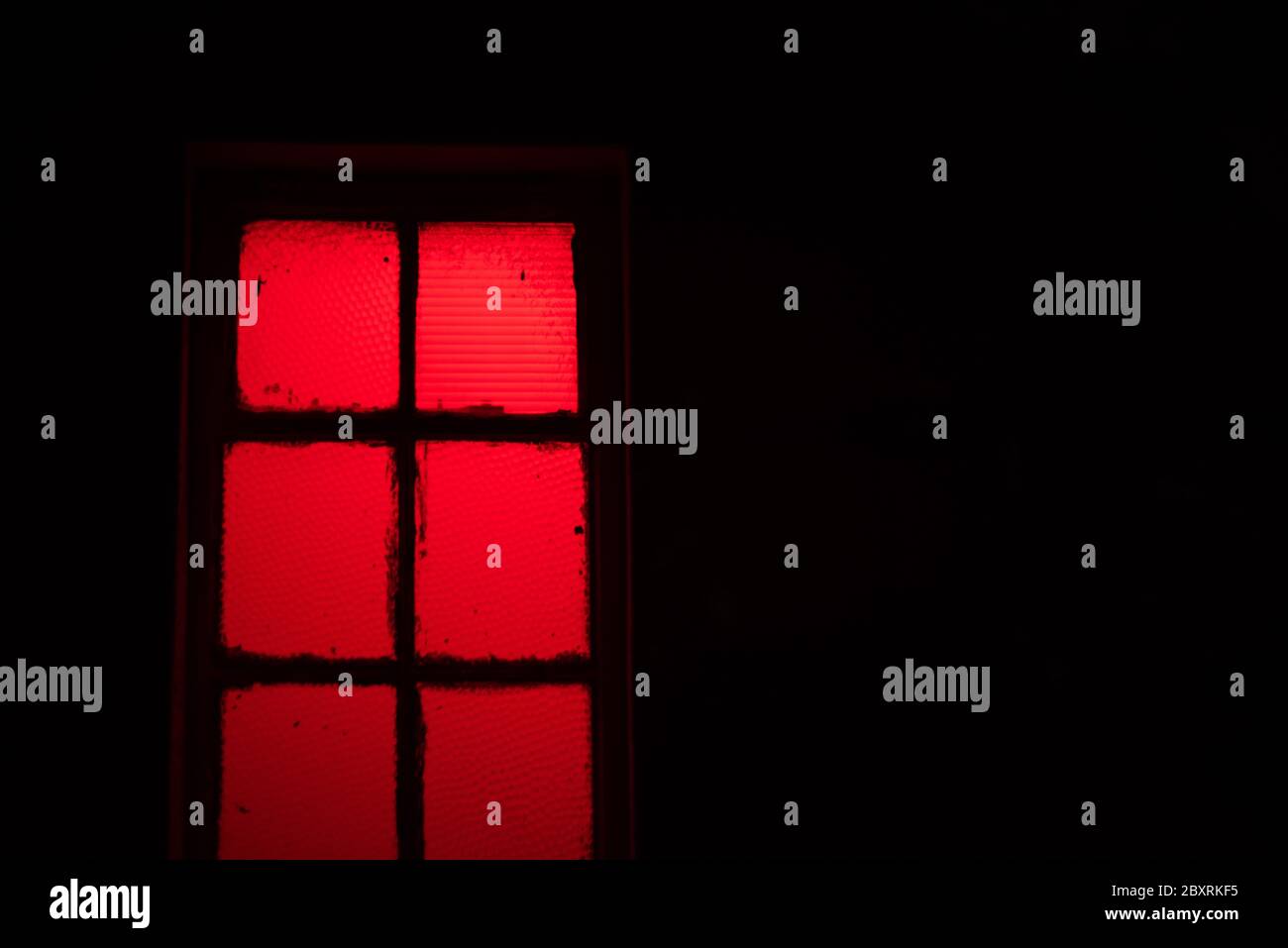 Window with red light shining at night Stock Photo - Alamy