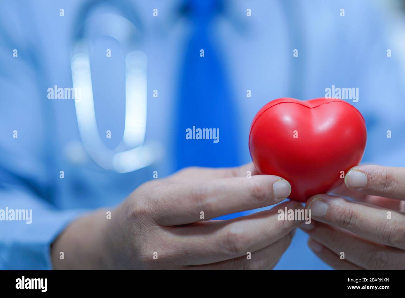 Doctor holding red heart in his hand in nursing hospital ward : healthy ...