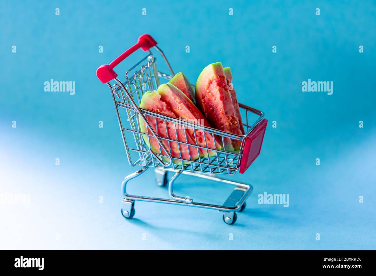 red guava plants inside supermarket cart on blue background Stock Photo ...