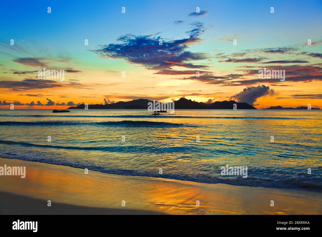 Tropical island at sunset Stock Photo - Alamy