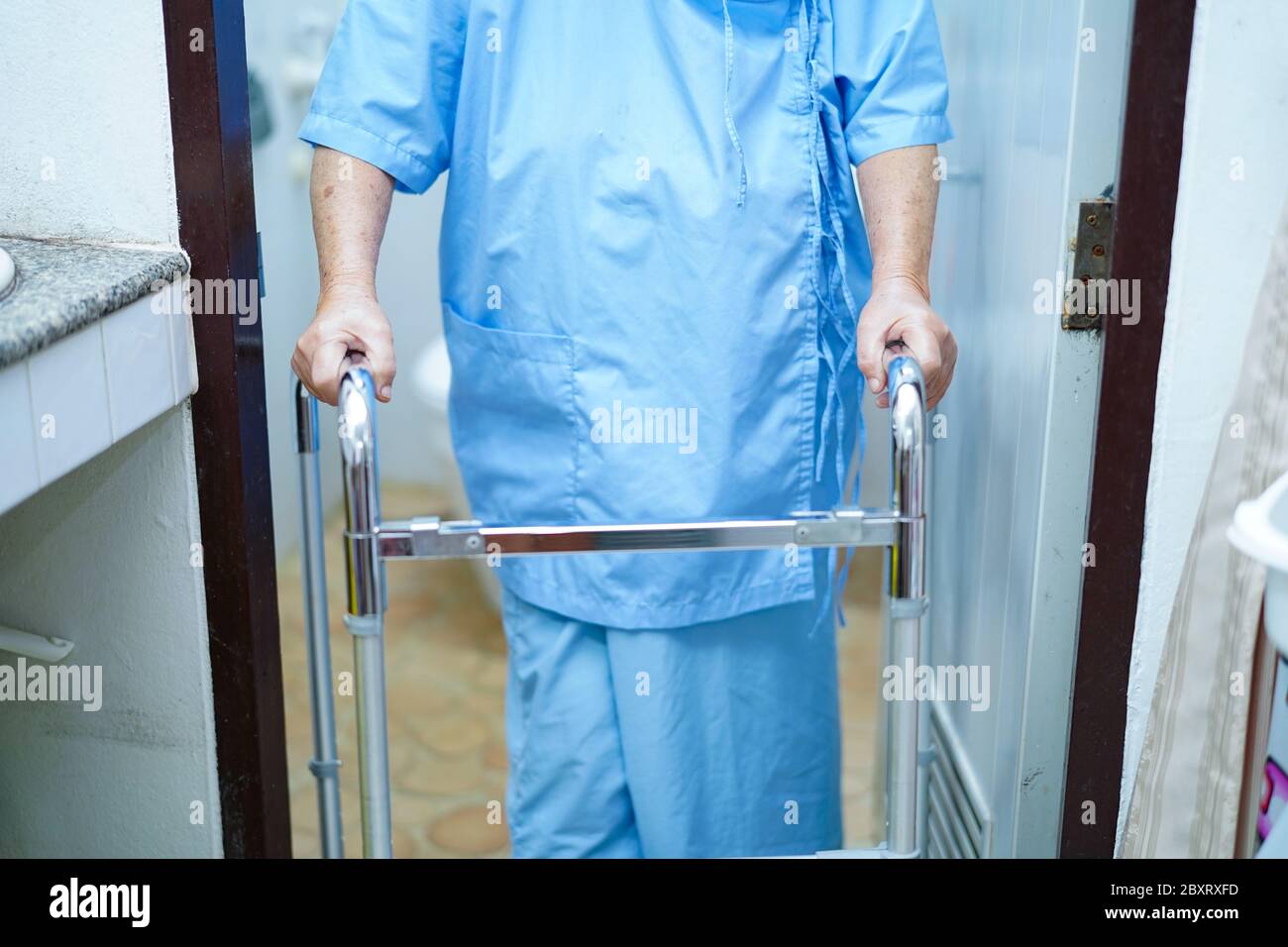 Asian senior elderly old lady woman patient walk with walker out from ...