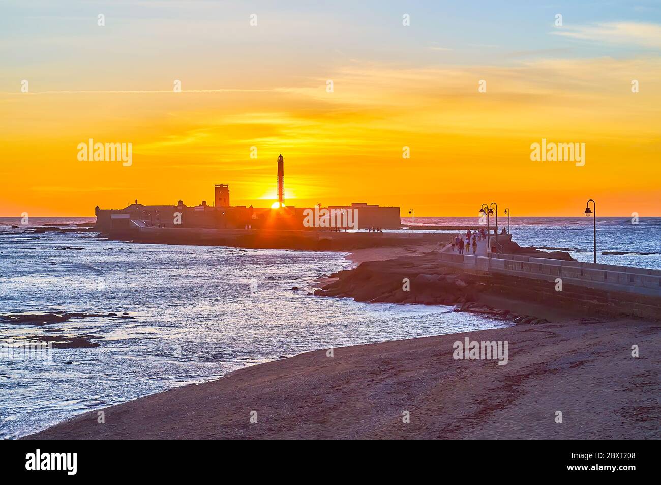 The evening walk along the coast of Atlantic Ocean with a view on fiery ...
