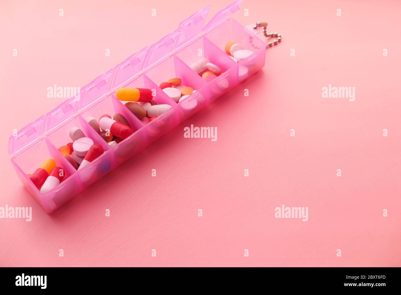 Top view of pill box on pink background Stock Photo - Alamy