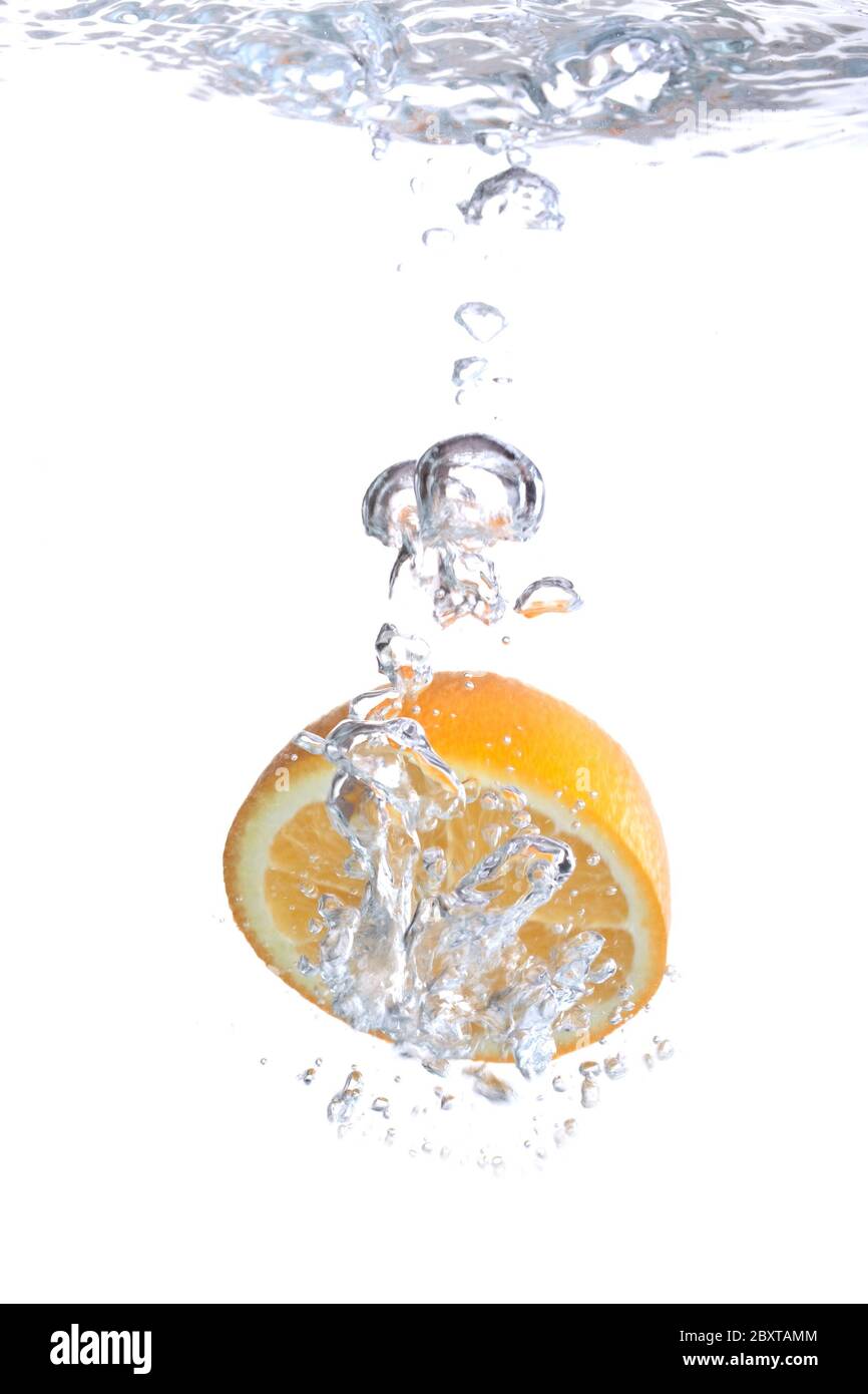 Orange falls into water Stock Photo - Alamy