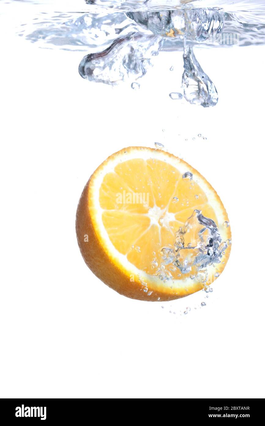 Orange falls into water Stock Photo - Alamy