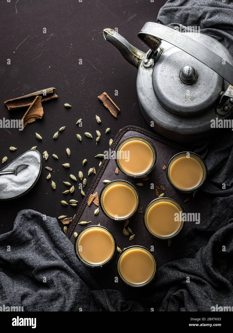 Indian chai in glass cups with metal kettle and other masalas to make ...