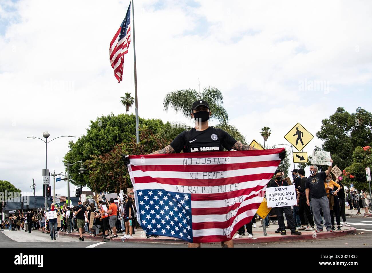 Man carrying an upside down American flag at a peaceful protest ...