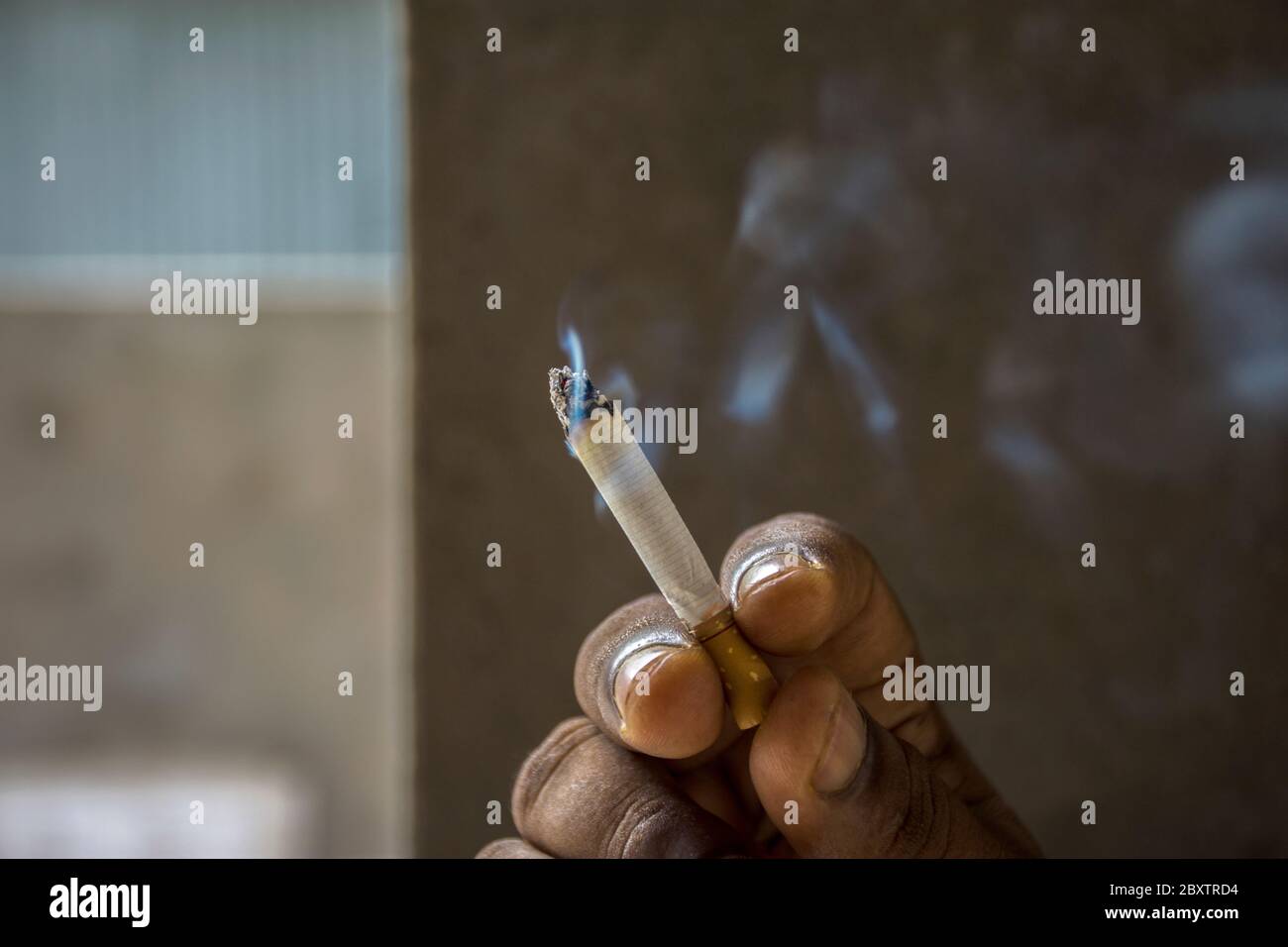cigarette with fire and smoke in hand Stock Photo - Alamy