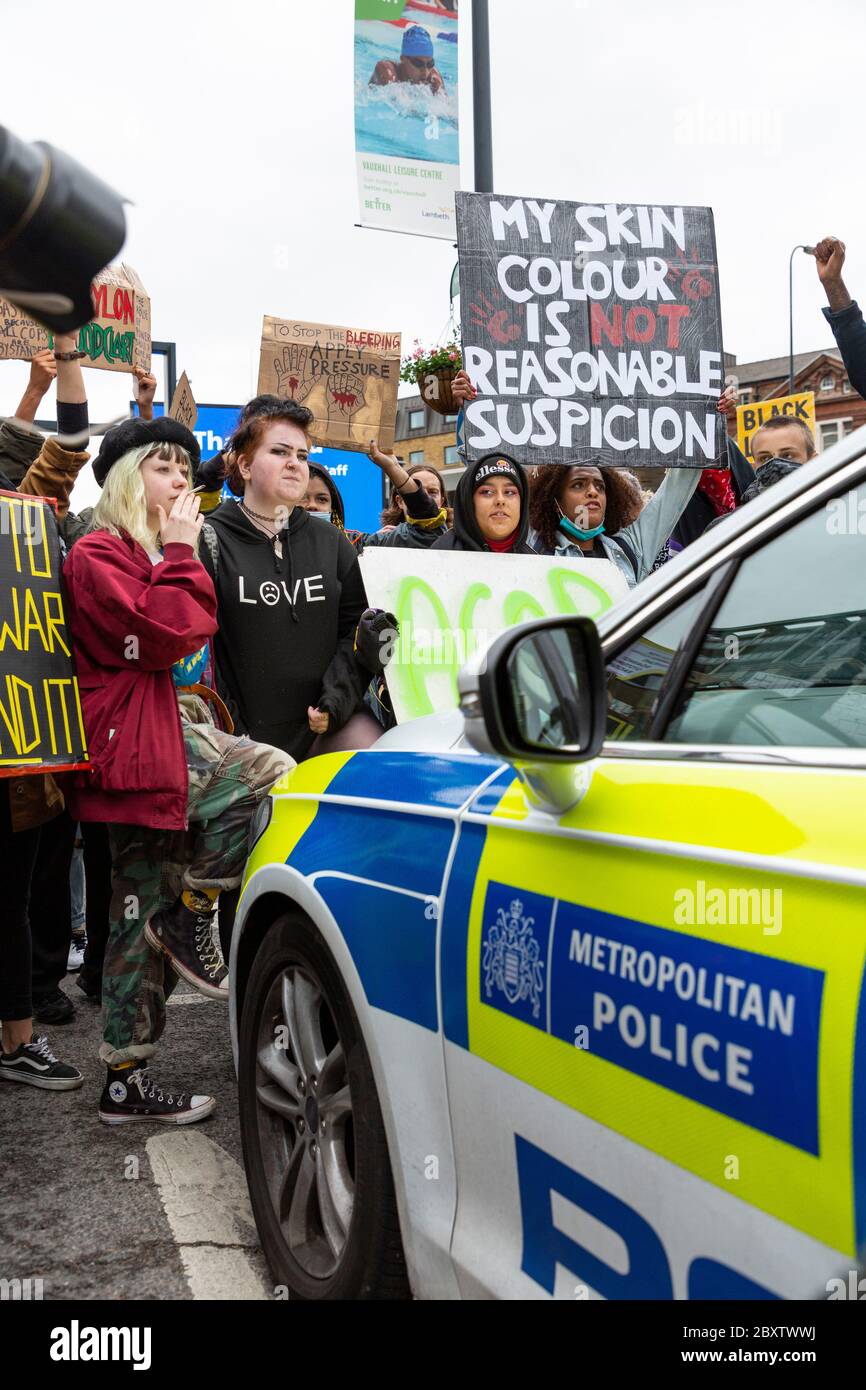 A crowd of protesters surround and obstruct a police car during the ...