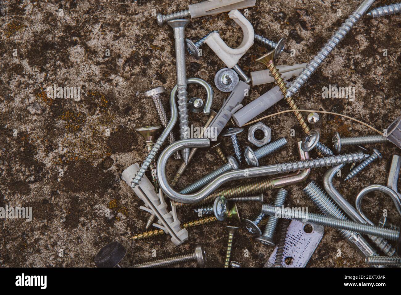 Rusty metal and steel bolts and nuts, hooks and dowels on grunge stone ...