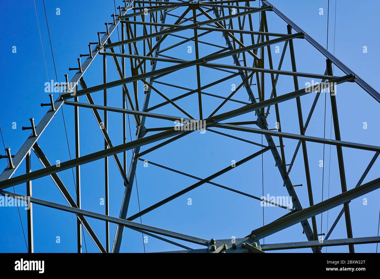 Low angle shot from below to the top of an electricity pylon against ...