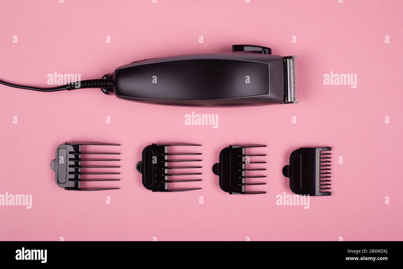 barber clipper for haircuts with nozzles of different sizes on a pink ...