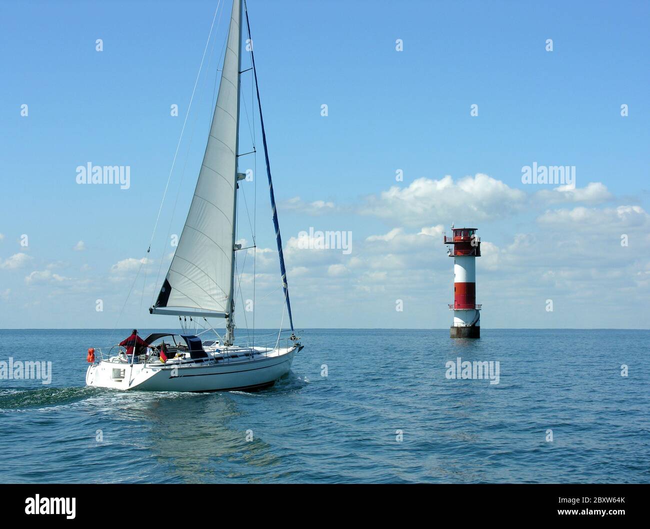 lighthouse and sailboat Stock Photo - Alamy