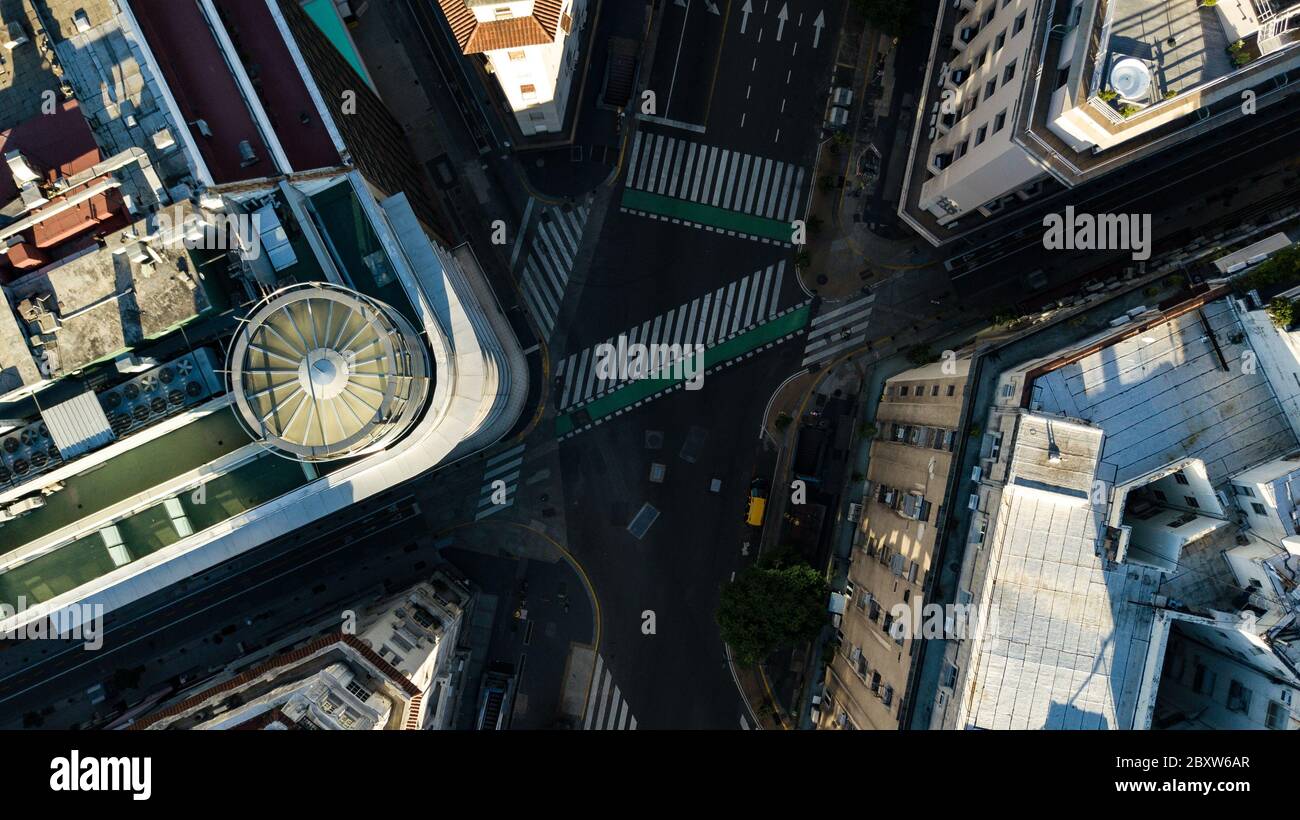 Aerial top down view on four way intersection in between tall buildings ...