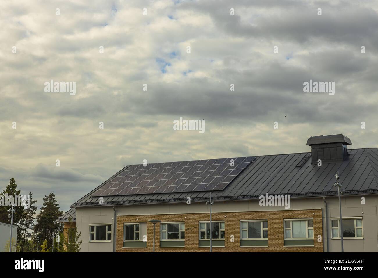 View of white yellow building with roof equipped with solar panels ...