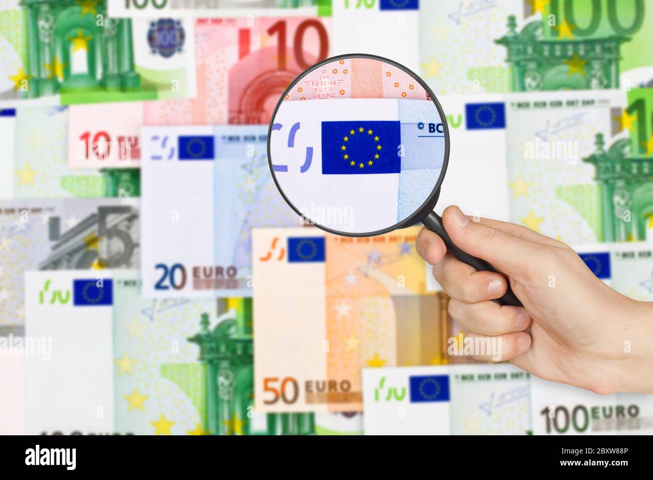 Money and magnifying glass in hand Stock Photo - Alamy
