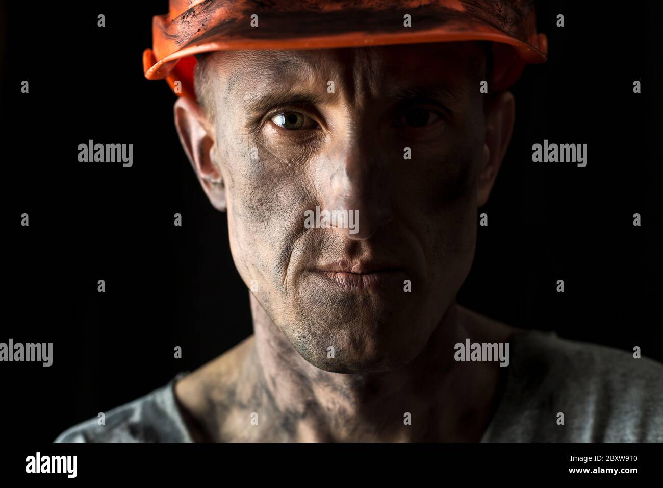The face of a male miner in a helmet on a black background Stock Photo ...