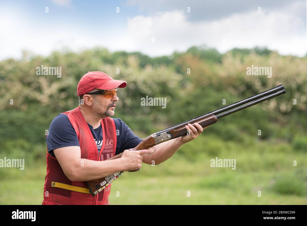 Man shooting skeet with a shotgun Stock Photo - Alamy