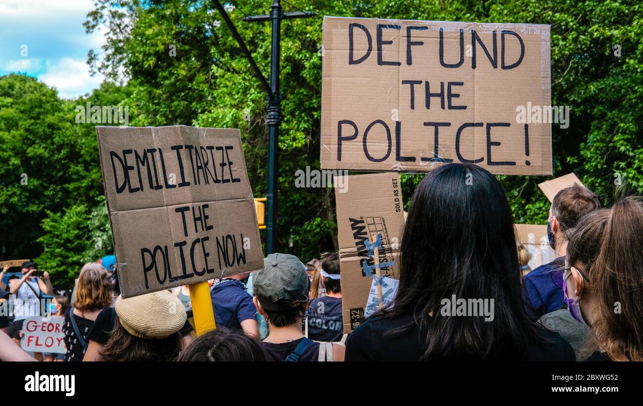 People in a family protest march in Brooklyn holding signs that say ...