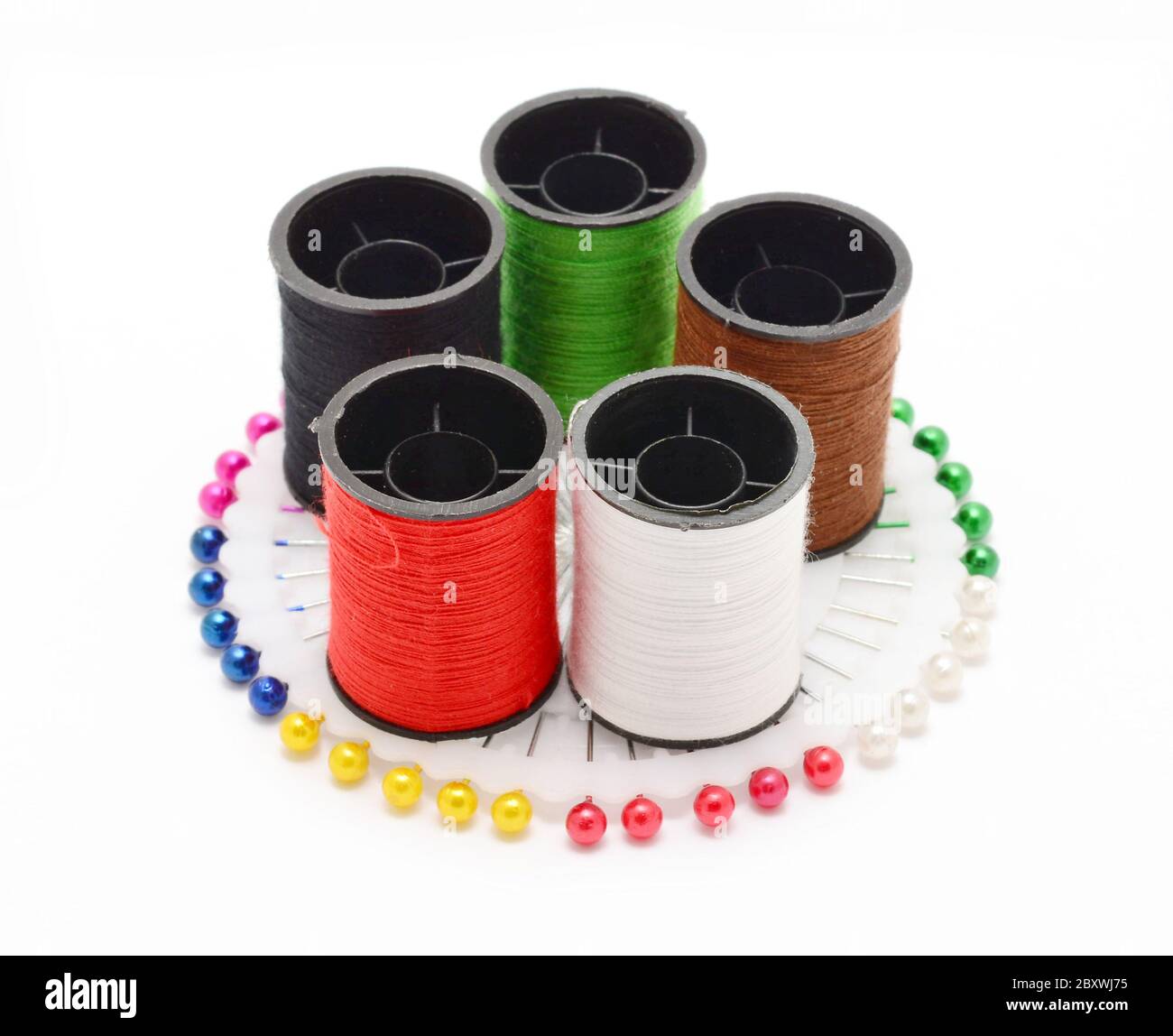 Set Of Color Sewing Threads On Colorful Sewing Pins Wheel Over White