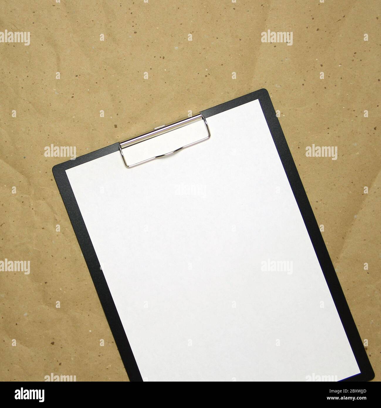 A tablet with a white sheet of A4 format on a beige craft paper ...