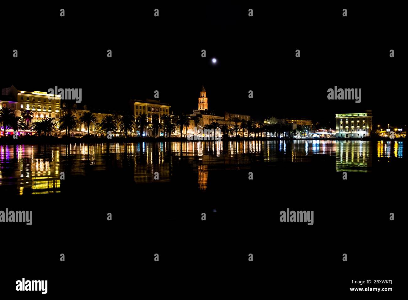 Split's Old Town buildings reflected in Split Harbour at night, Croatia ...