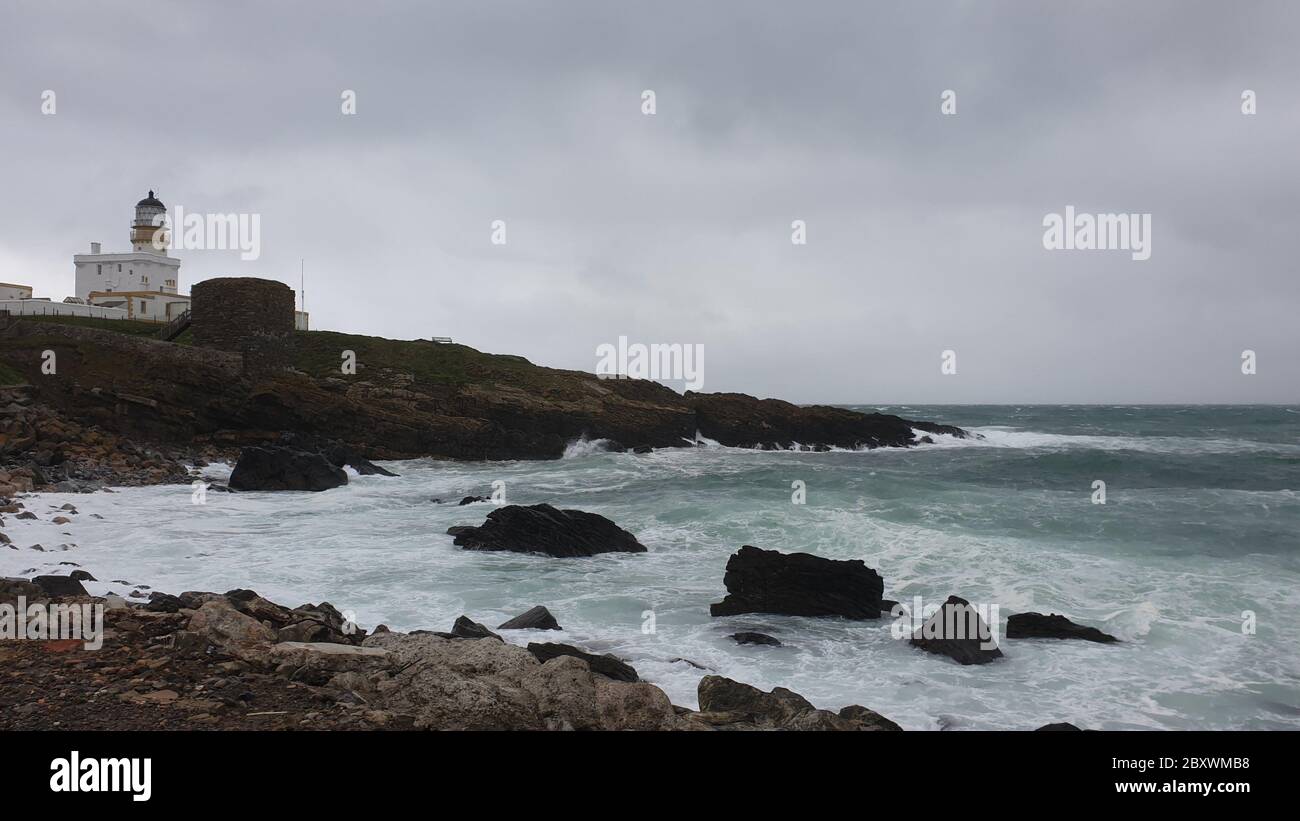 Lighthouse by rough sea Stock Photo - Alamy