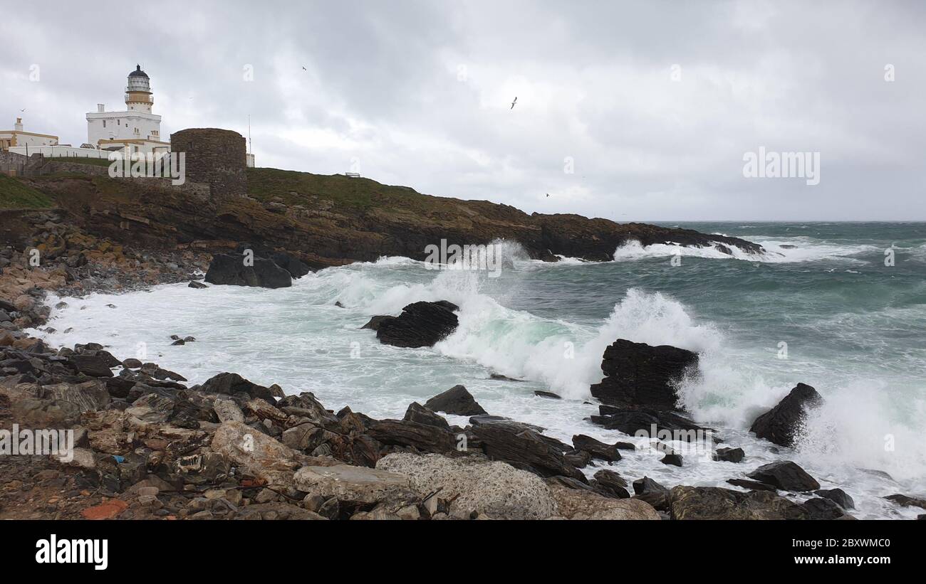 Lighthouse by rough sea Stock Photo - Alamy