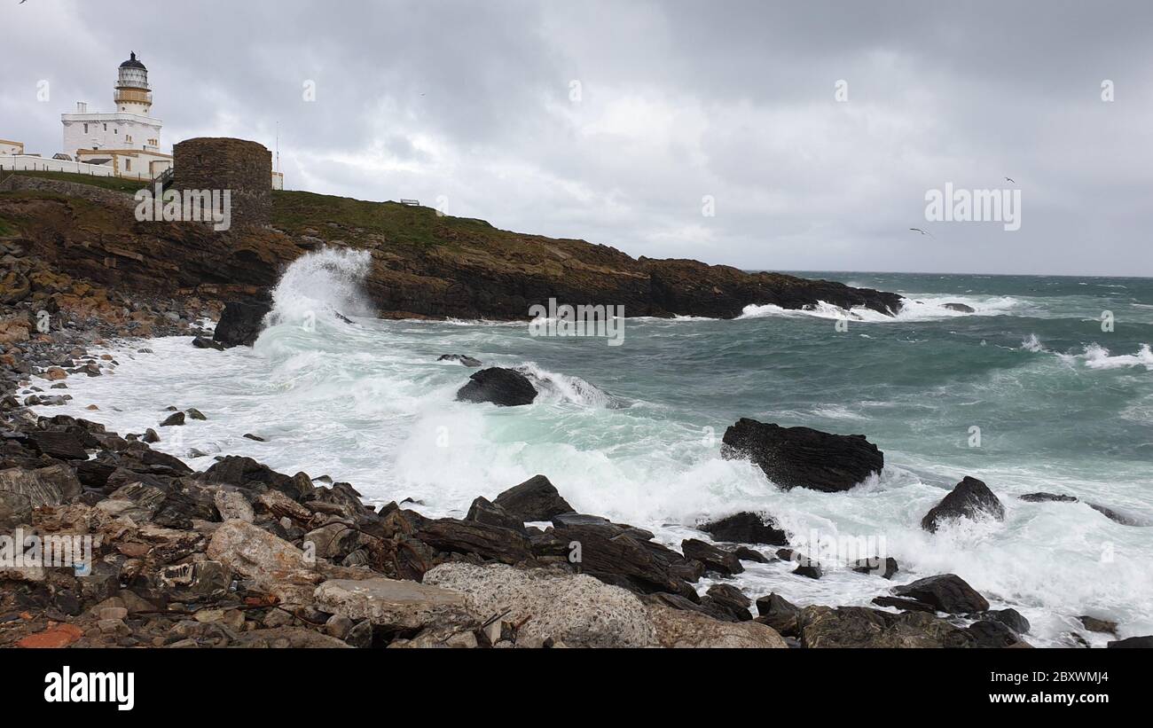 Lighthouse by rough sea Stock Photo - Alamy