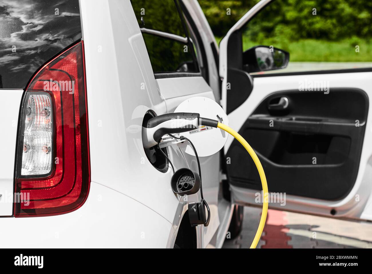 Yellow electric socket charging an electric car in the street. Power ...