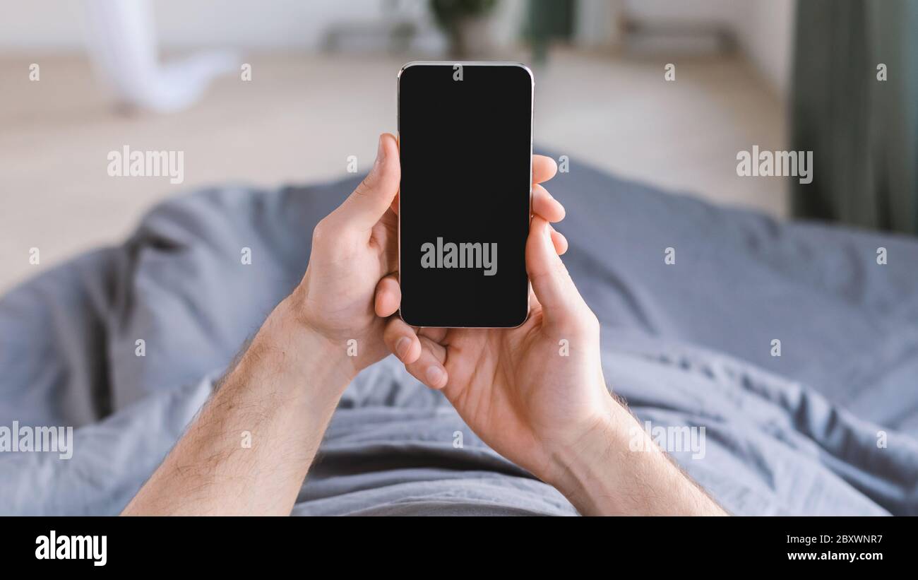 Man Using Smartphone With Empty Screen Lying In Bed, POV Stock Photo ...