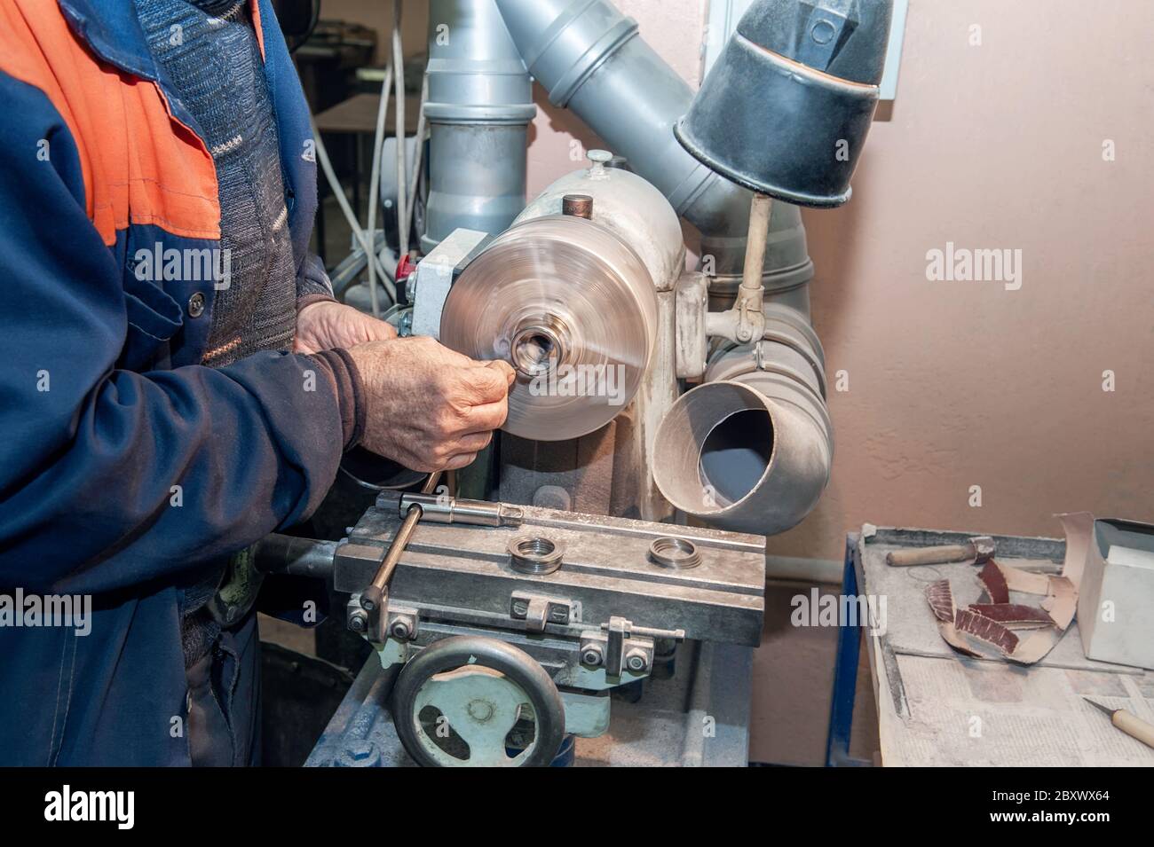 master grinds metal product. The old Metalworking machine, manufactured ...