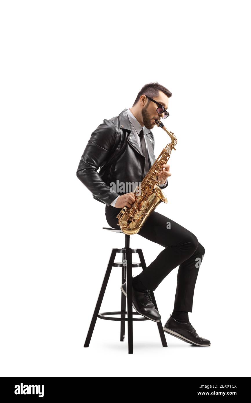 Man in a leather jacket sitting on a chair and playing a saxophone ...