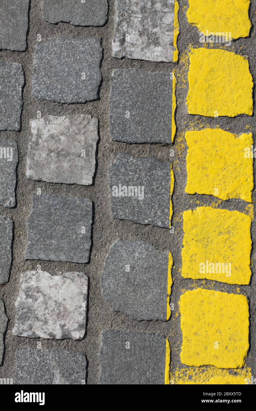 Gray cobblestone background with yellow stripe Stock Photo - Alamy