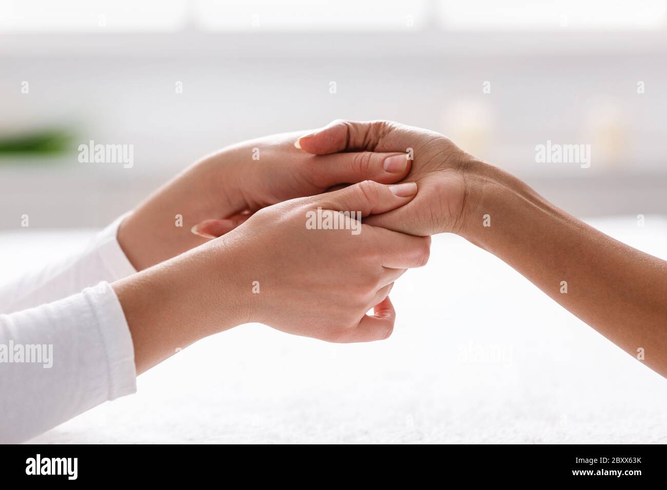 Physiotherapist pressing specific spots on female palm Stock Photo - Alamy