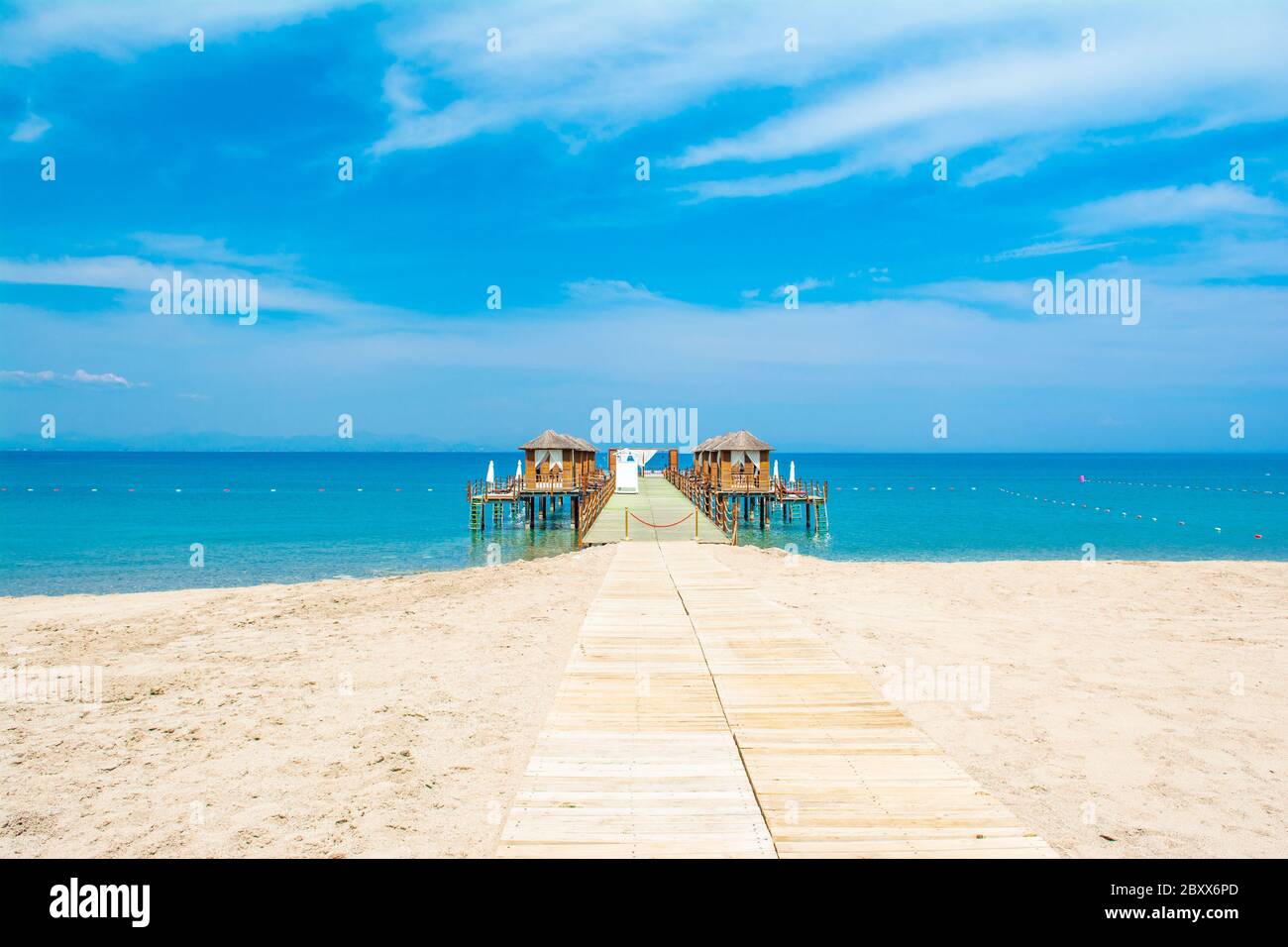 Wooden beach pavilions on the shore of a sandy beach - the ...