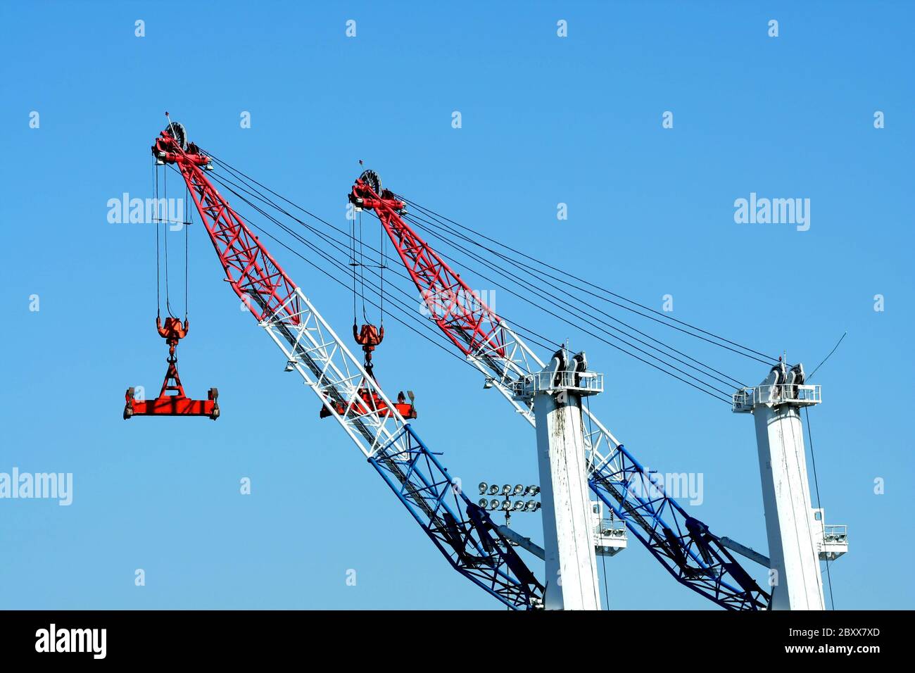 Two cargo container cranes with blue sky Stock Photo - Alamy