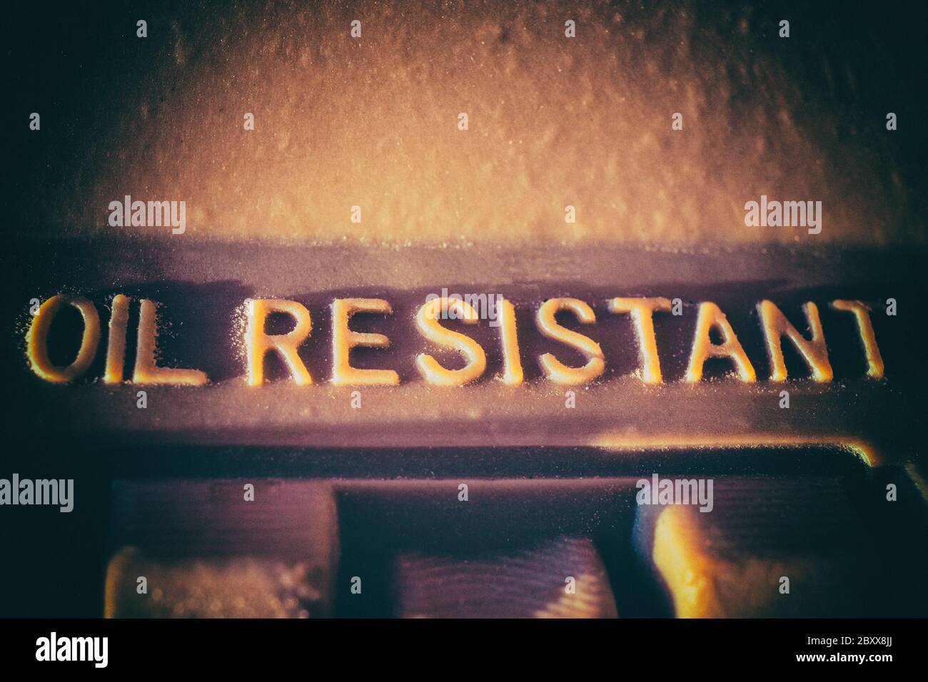 The word "Oil RESISTANT" written in vintage press stamp Stock Photo - Alamy