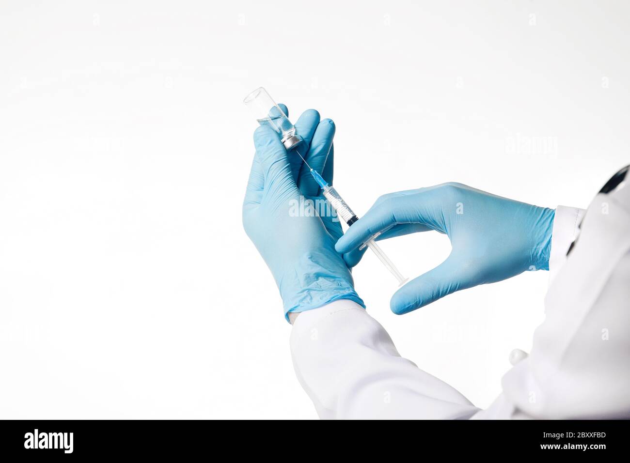 Close up doctor arm using syringe and ampoule on white background ...