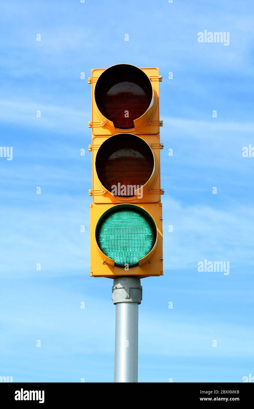 Green traffic signal light against blue sky Stock Photo - Alamy