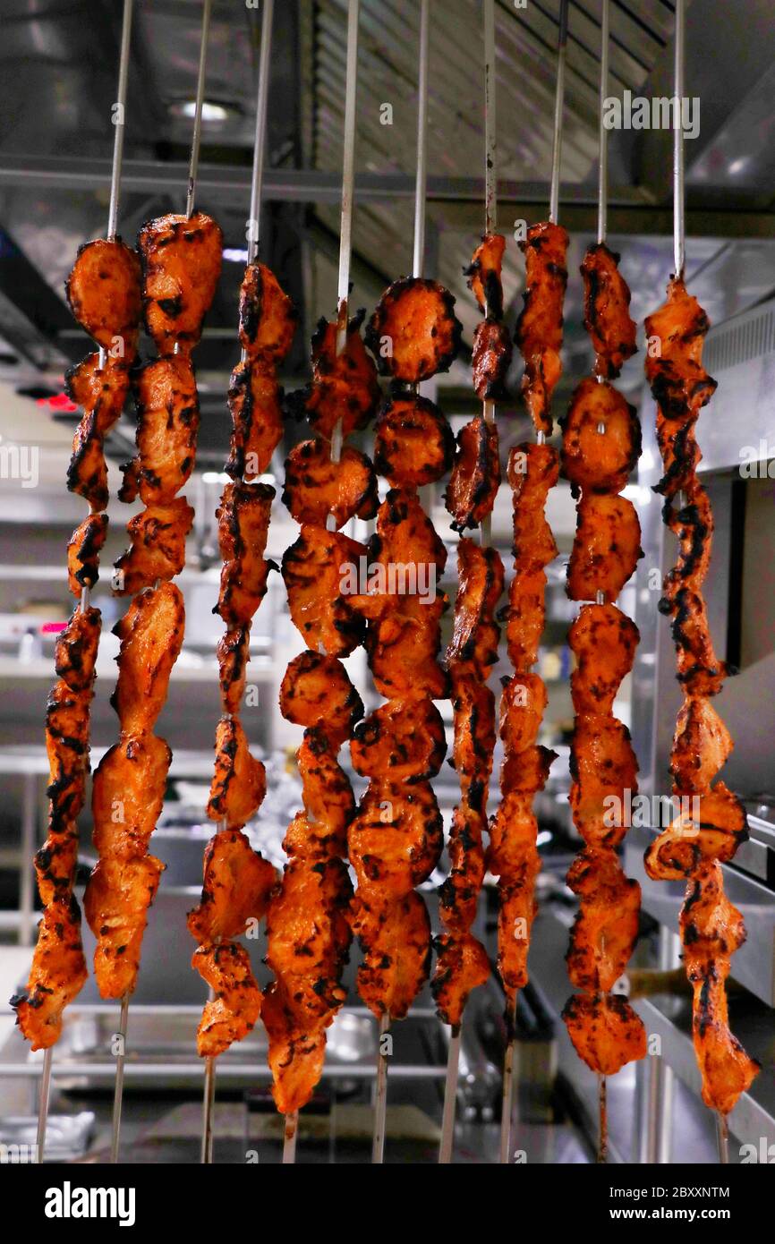 spice marinated chicken cubes ( chicken tikka )skewers cooking in a ...