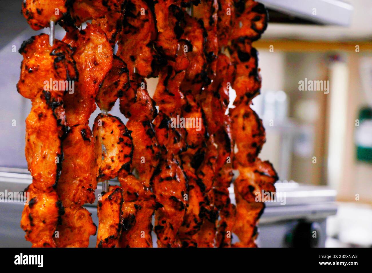 spice marinated chicken cubes ( chicken tikka )skewers cooking in a ...