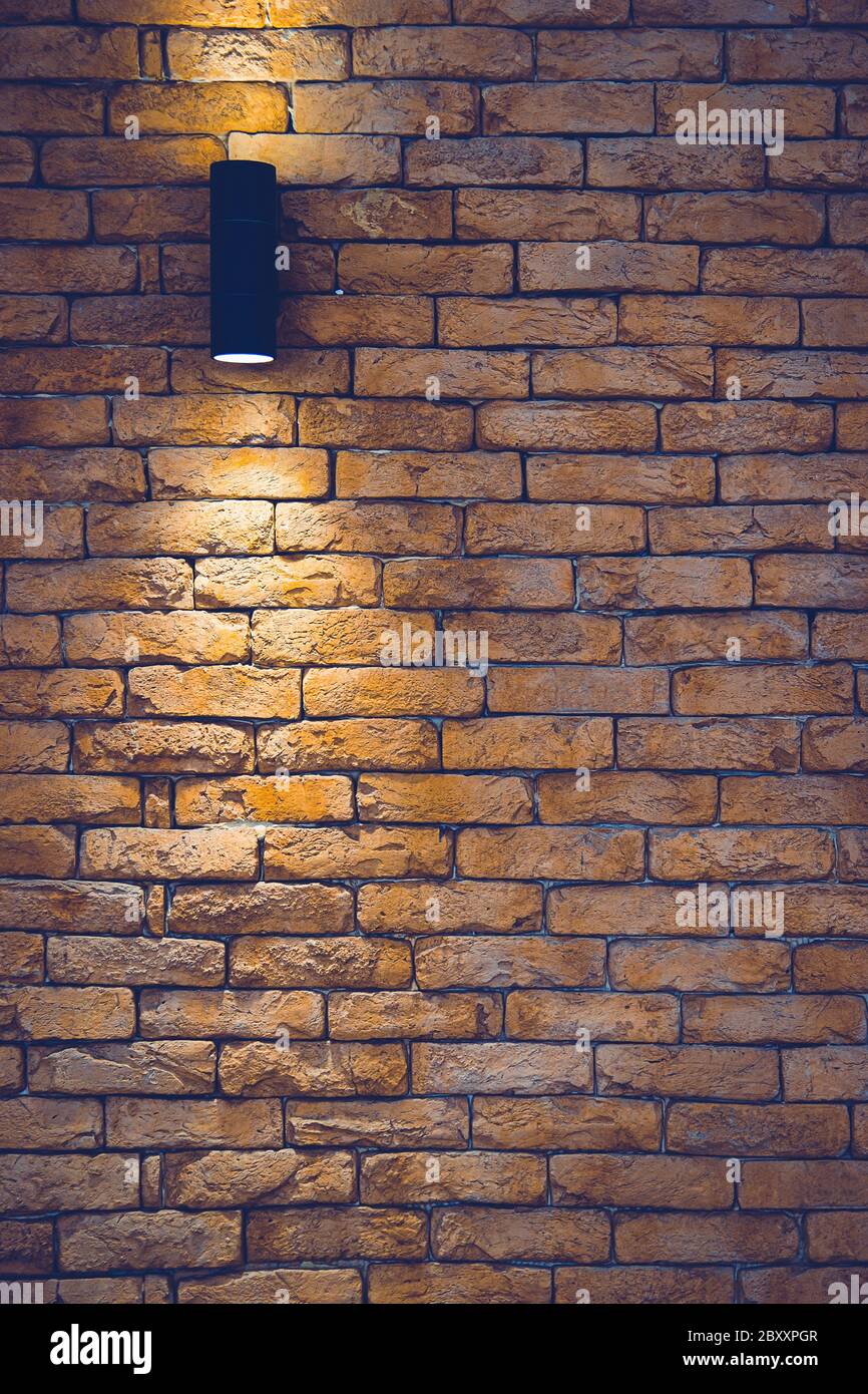 A section of a brown brick wall with an artificial light lamp Stock ...
