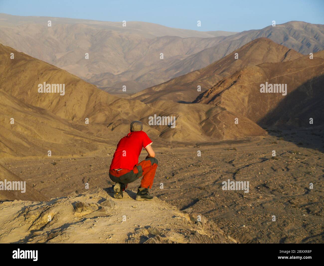 Young man looking around desert Stock Photo - Alamy