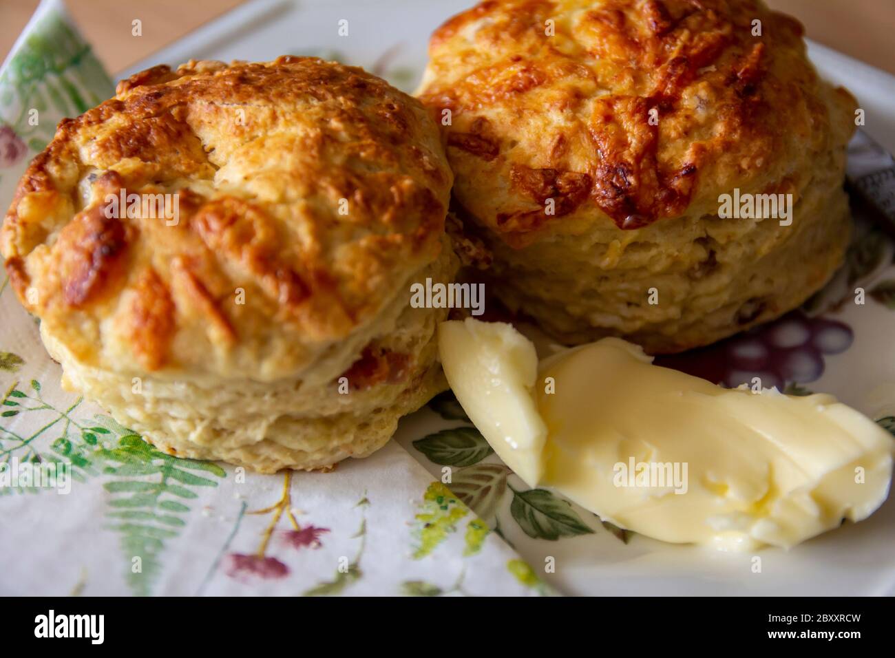 Two Bacon and Cheese Scones on a side plate with napkin and portion of ...