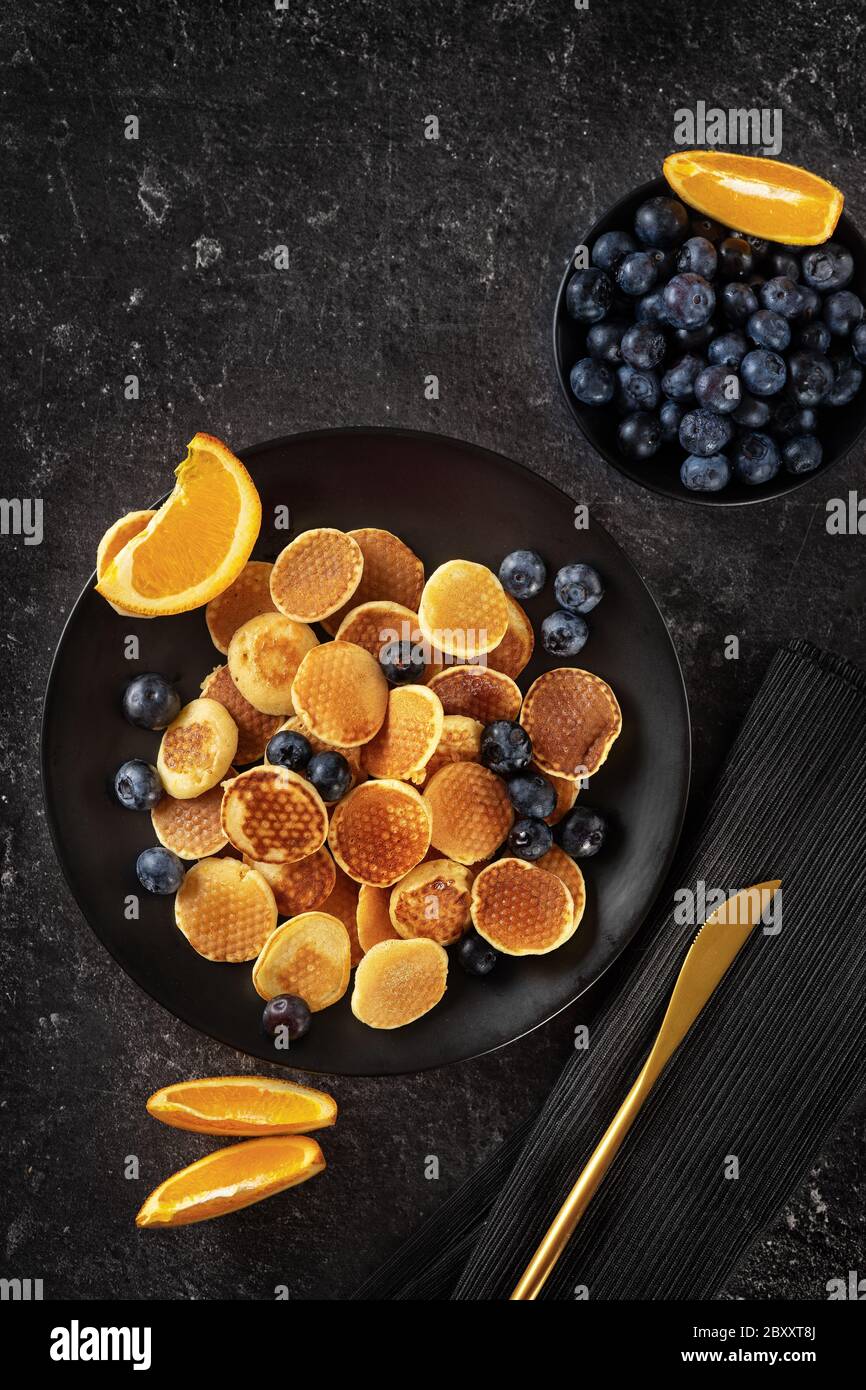 Top view over trendy mini pancakes on black background Stock Photo - Alamy