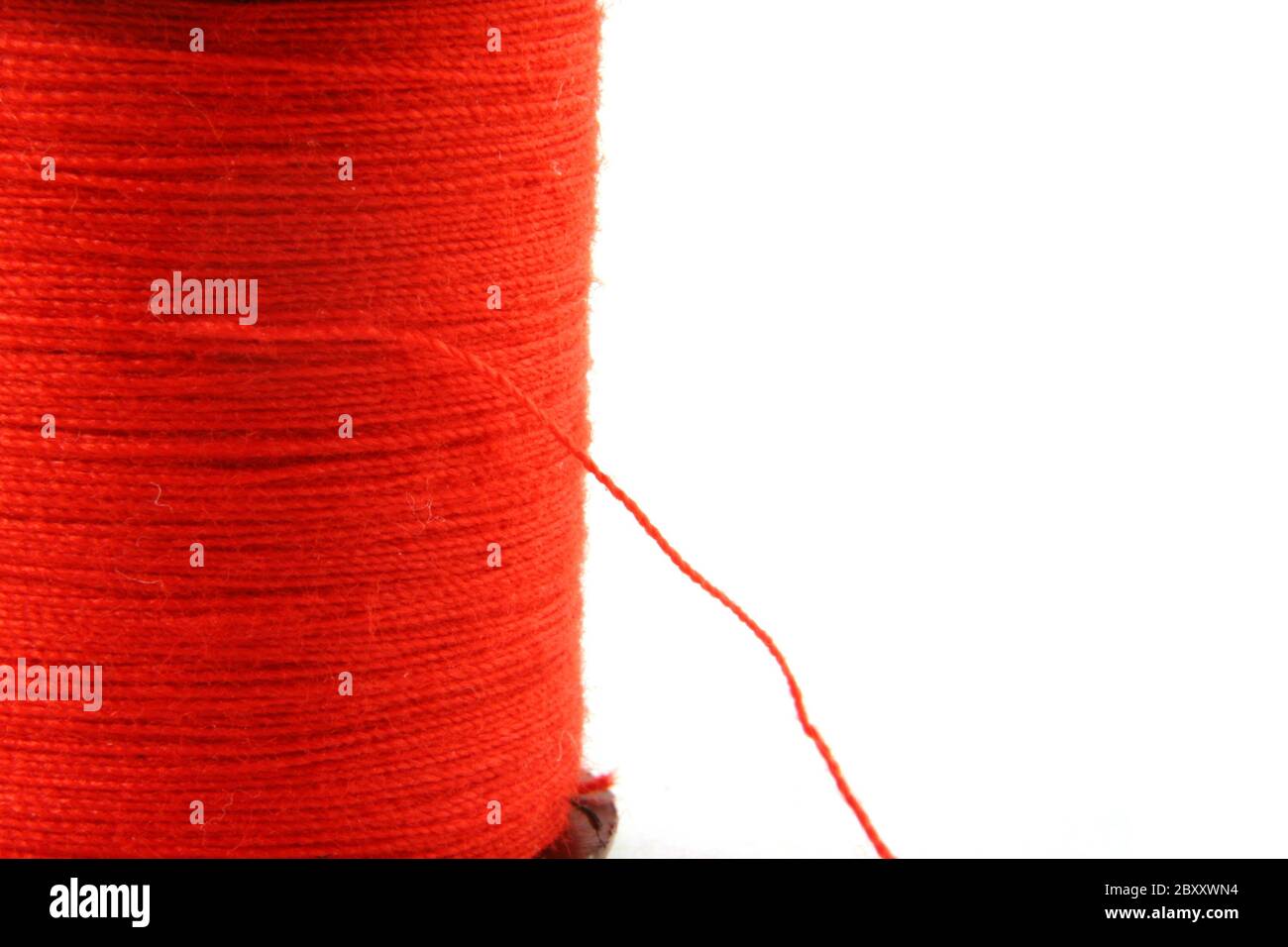 Red spool of thread over white Stock Photo - Alamy